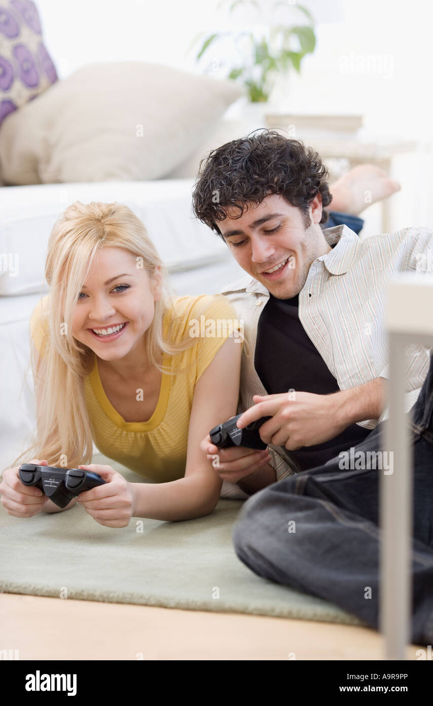 Couple playing video games on floor Stock Photo - Alamy