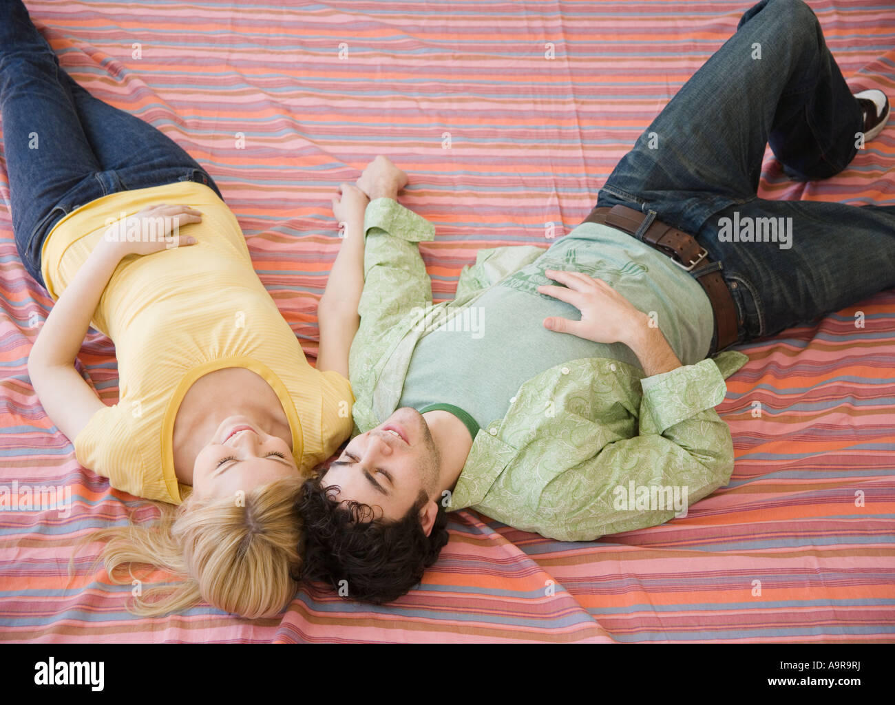 Couple laying on floor Stock Photo - Alamy