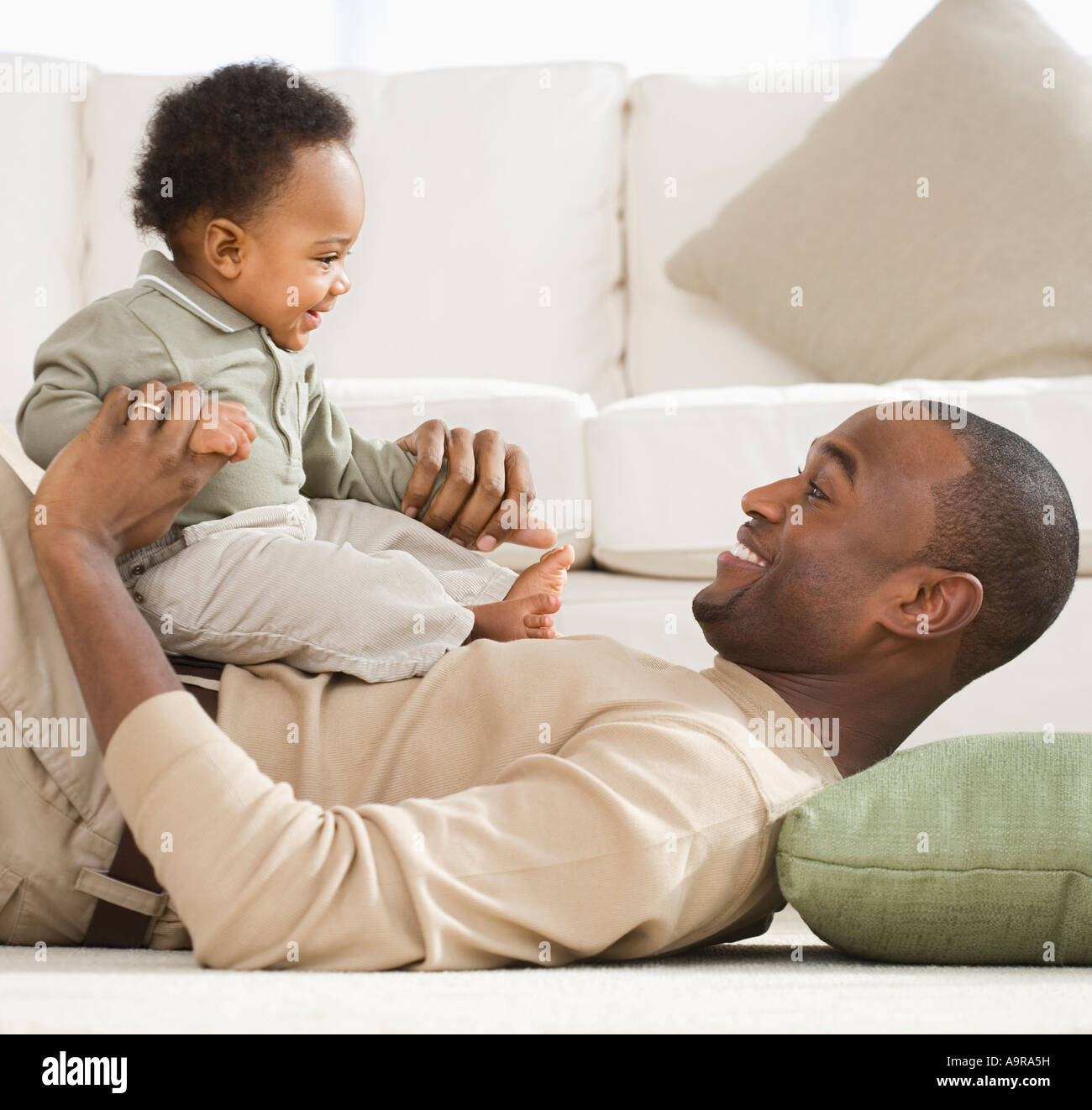 Father playing with baby on floor Stock Photo - Alamy