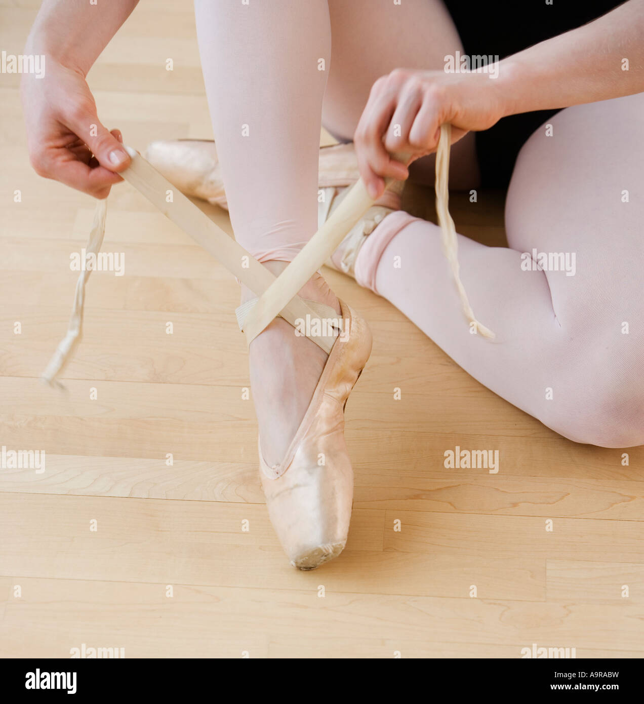 Female ballet dancer tying pointe shoes Stock Photo - Alamy