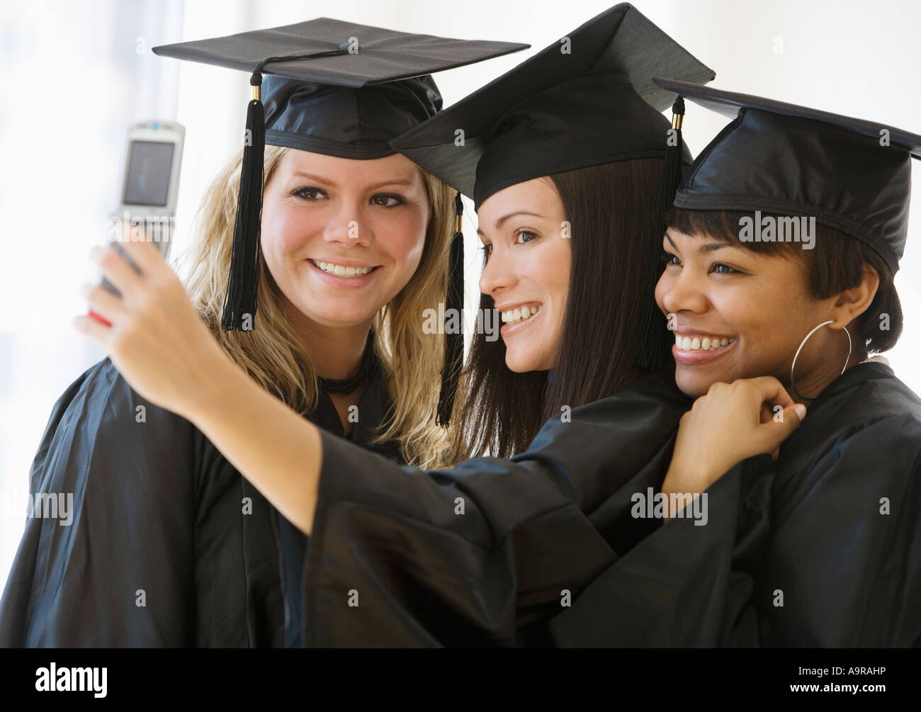 Multi ethnic female graduates taking own photograph Stock Photo - Alamy
