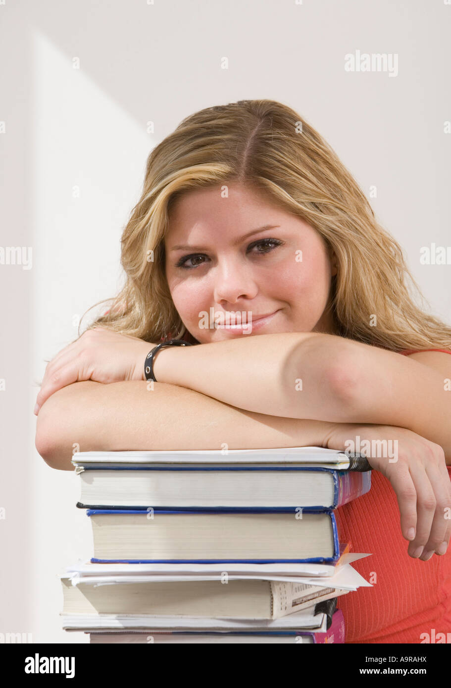 Woman leaning on stack of books Stock Photo - Alamy
