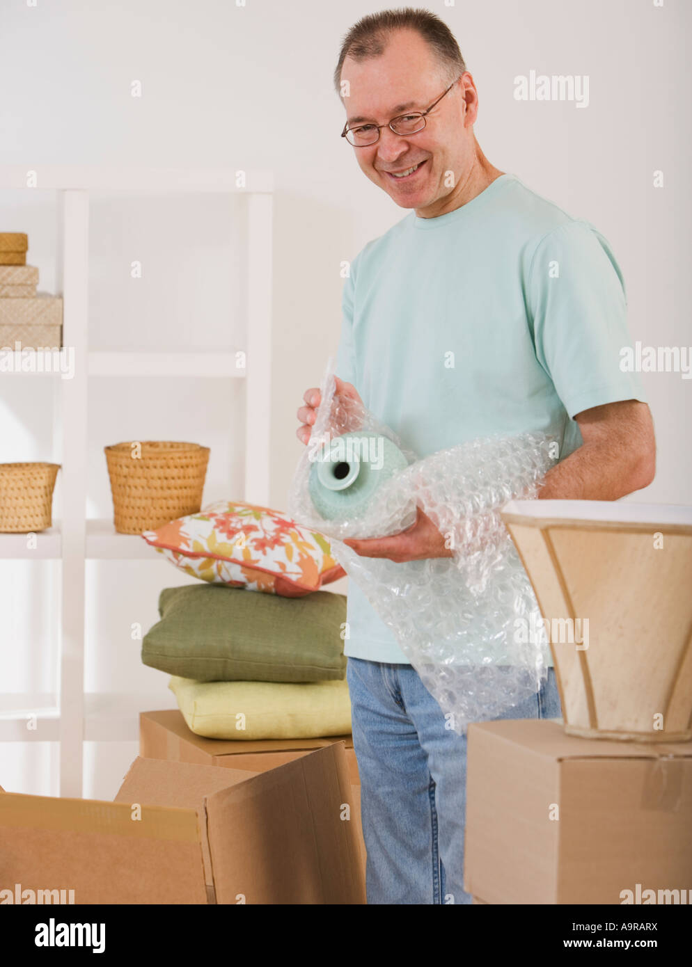 Man unpacking moving boxes Stock Photo - Alamy