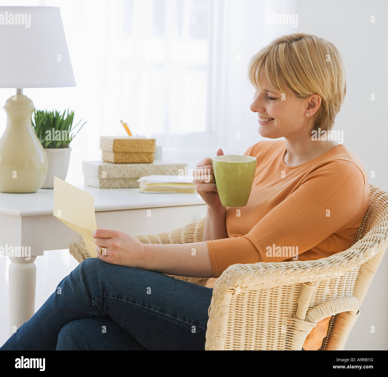 Woman reading letter at desk Stock Photo - Alamy
