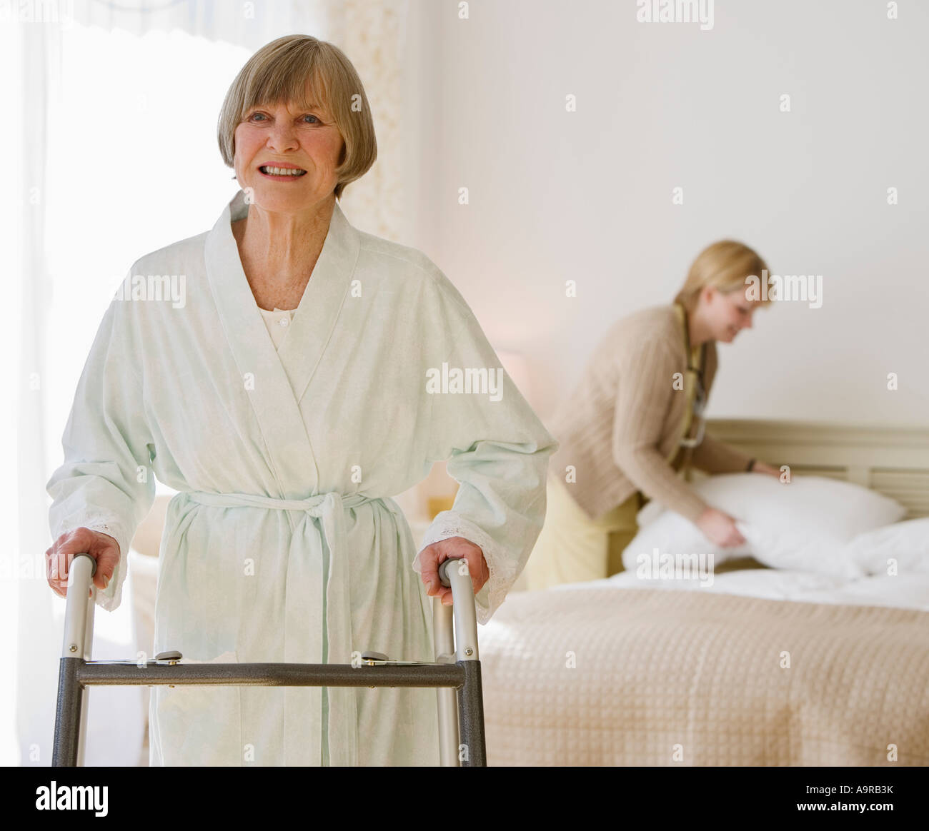 Senior woman using walker in bedroom Stock Photo - Alamy
