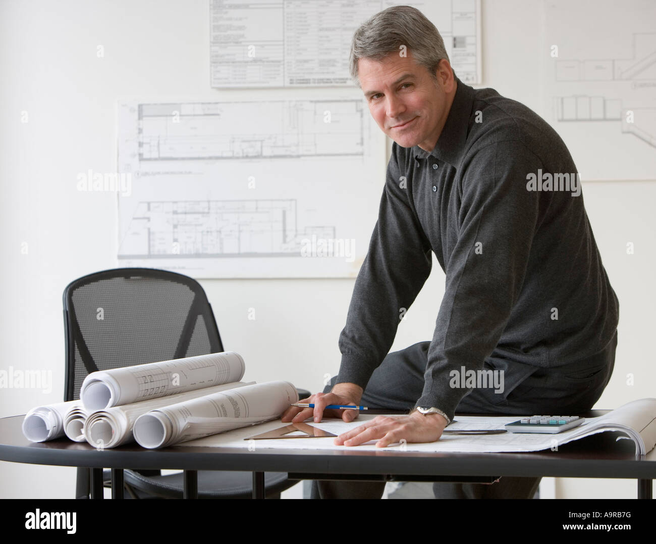Male architect next to blueprints Stock Photo - Alamy