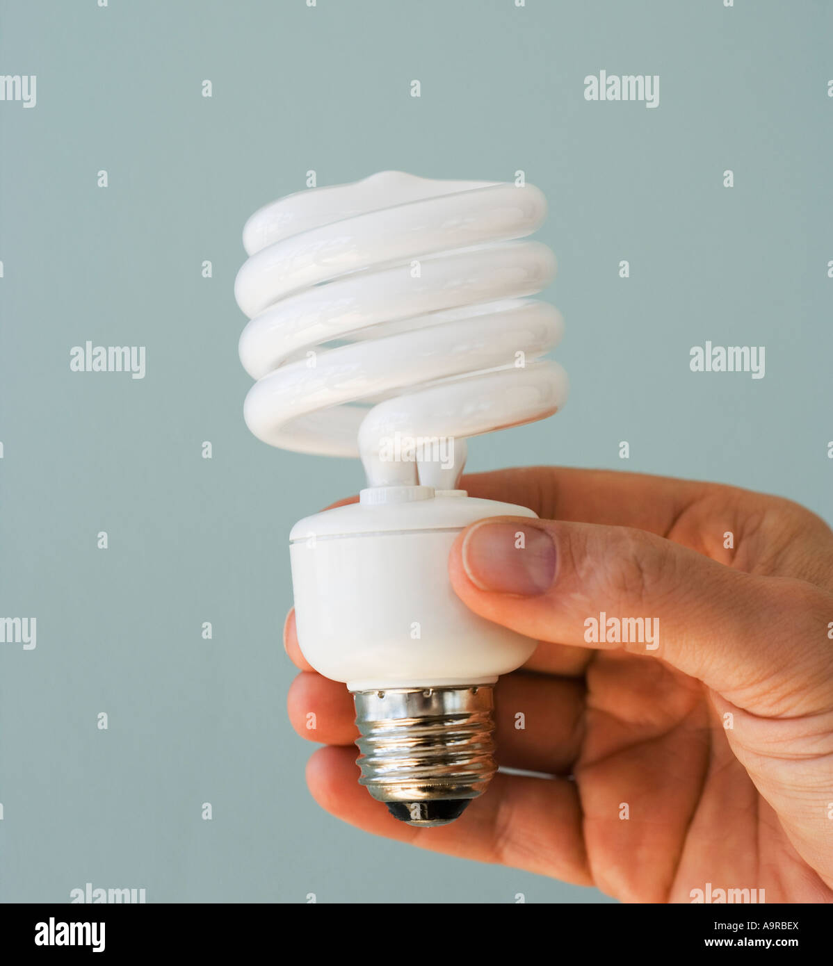 Man holding energy efficient light bulb Stock Photo - Alamy