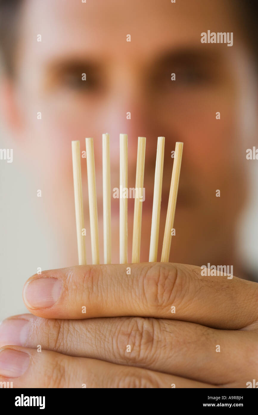 Man holding toothpicks Stock Photo - Alamy