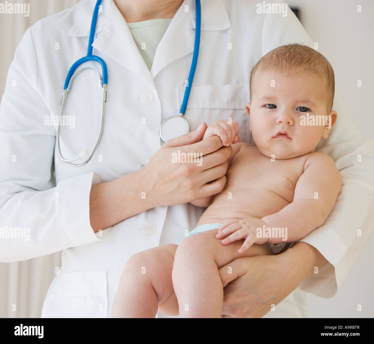 Female doctor holding baby Stock Photo - Alamy