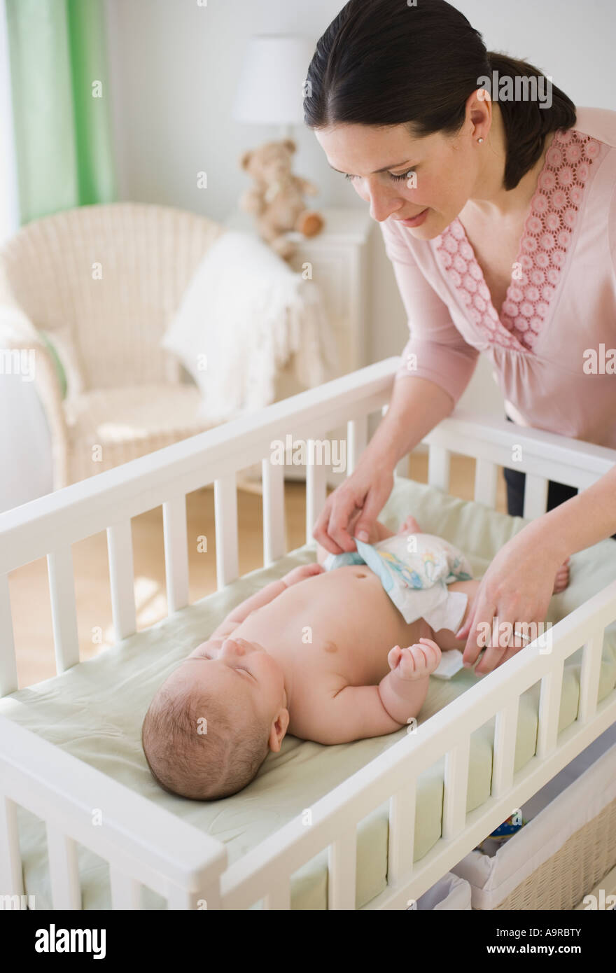 Mother changing baby s diaper Stock Photo - Alamy