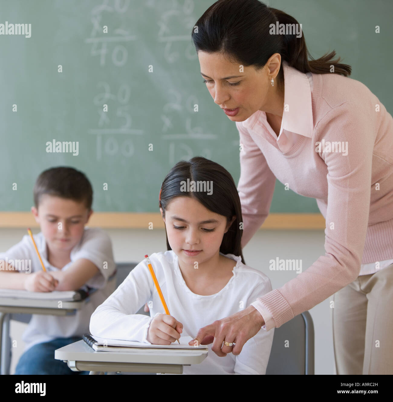 Female teacher helping student Stock Photo - Alamy
