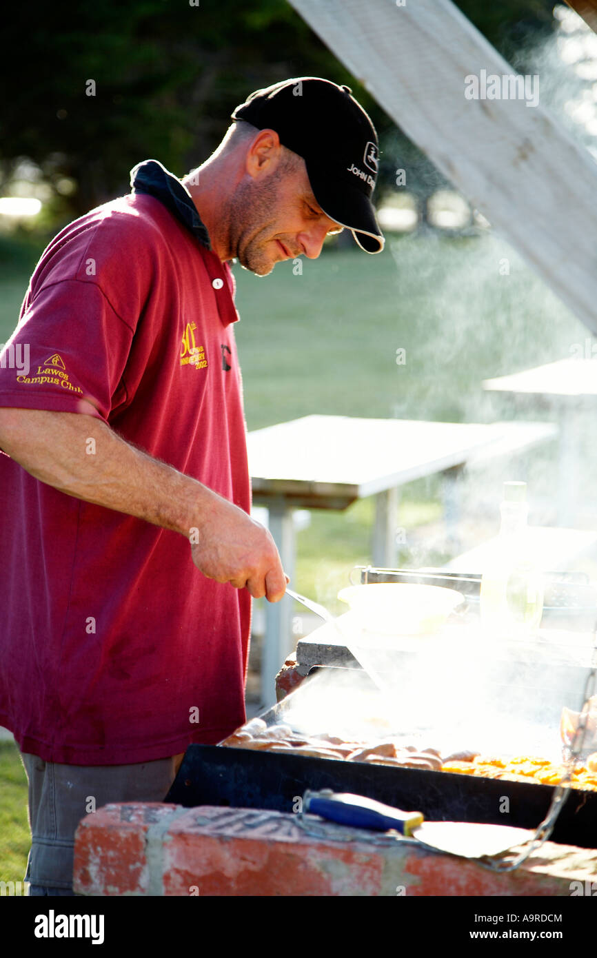 man cooking on a campsite bbq Stock Photo - Alamy