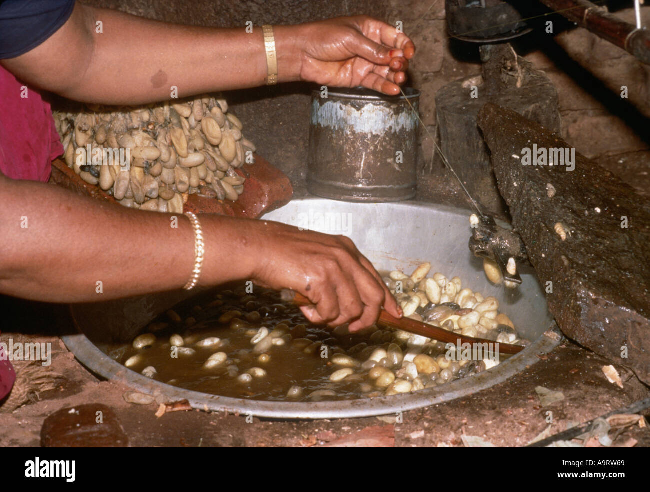Close-up of the hands of a female factory worker unwinding silk threads ...