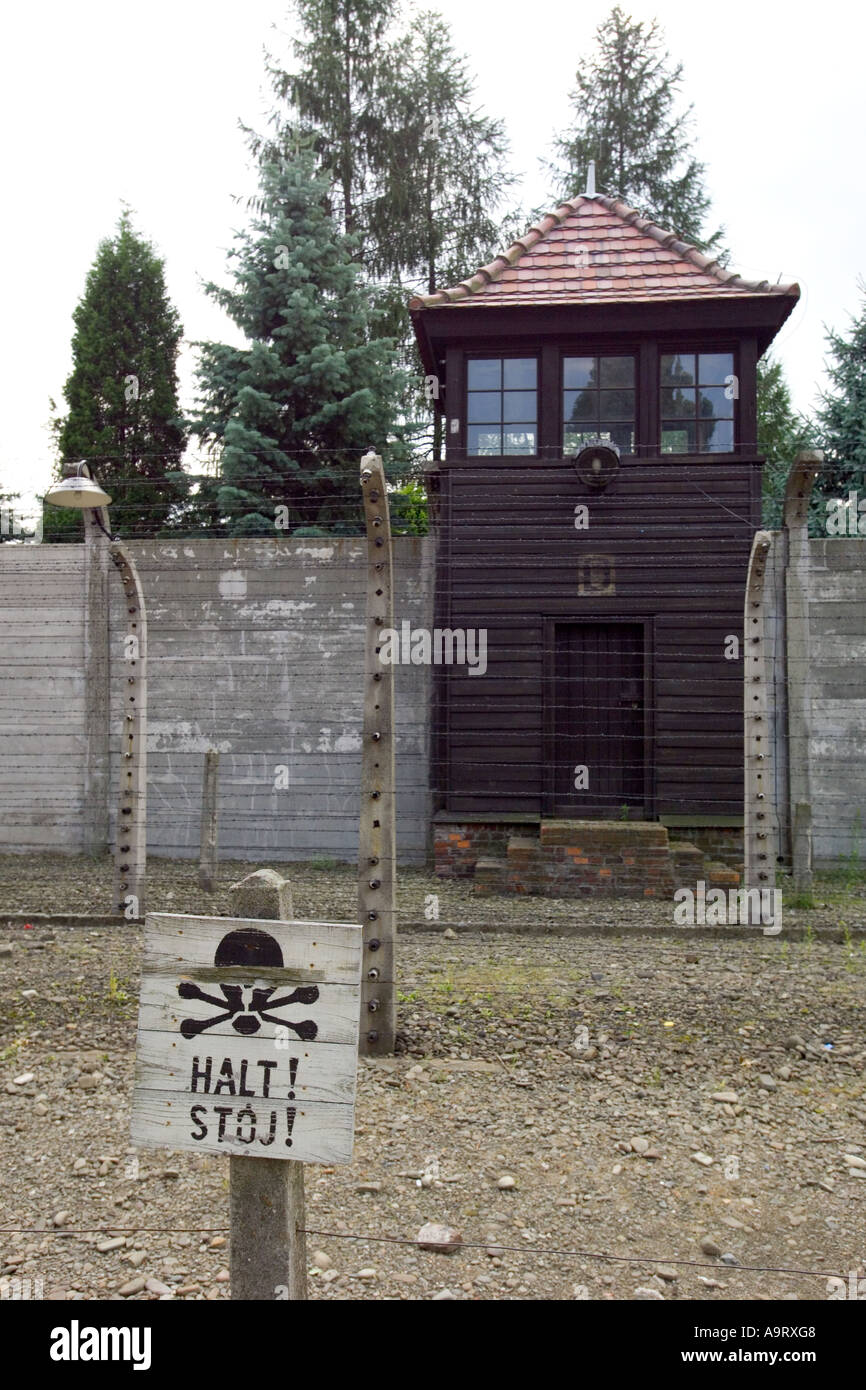 A view of a "HALT" sign, guard tower and barbed wire fence at Auschwitz ...