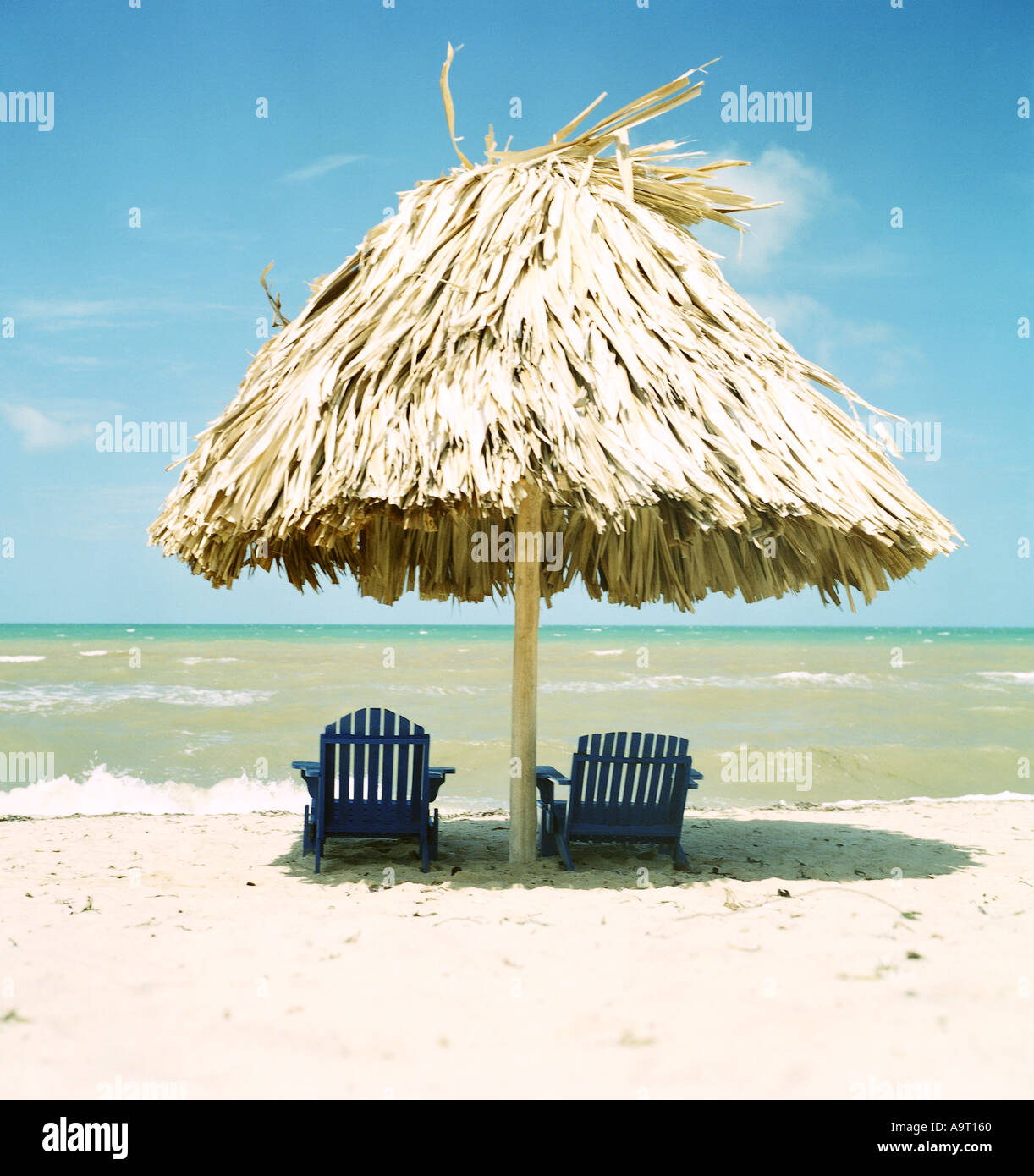 Two sun chairs under a palapa on a beach in Southern Belize Stock Photo ...