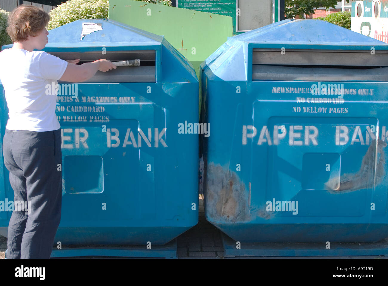A woman puts a newspaper into a recycling paper bank Stock Photo - Alamy