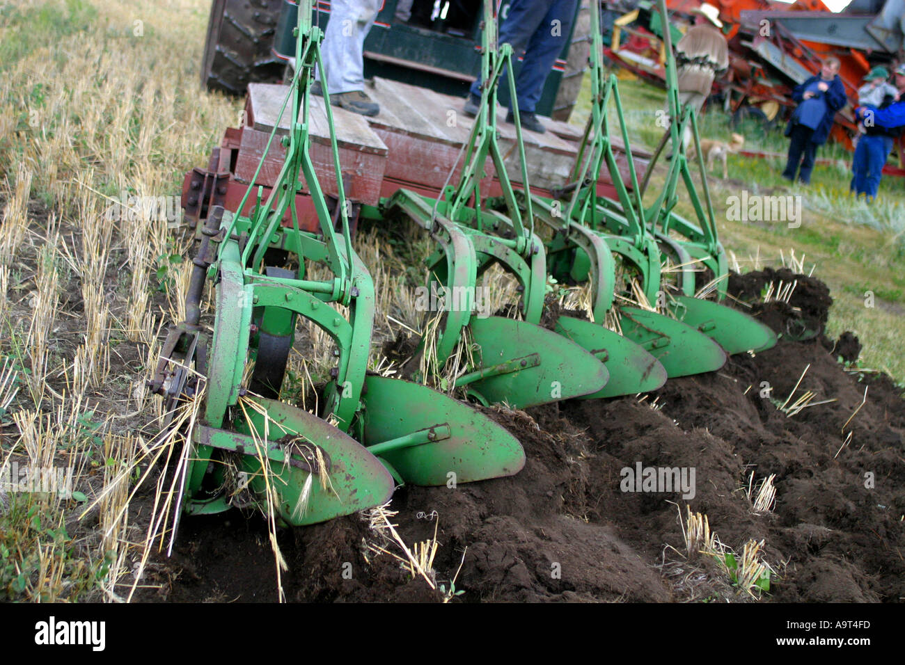Horizontal Antique tractor pulling a five furrow plough Stock Photo - Alamy