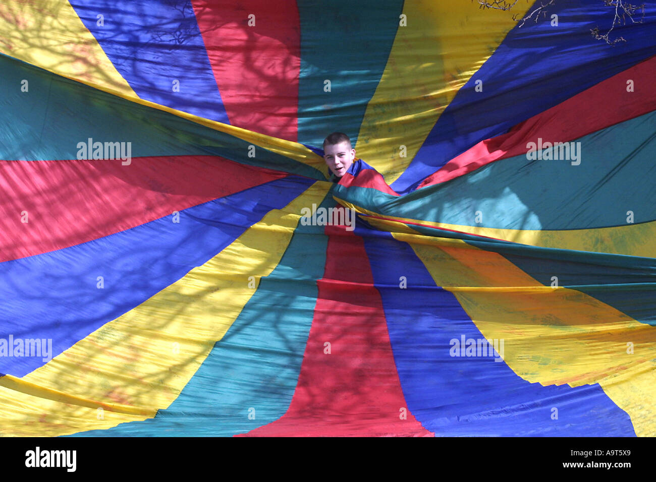 Young Boy playing with Parachute Silk at an organized fun day in the UK ...