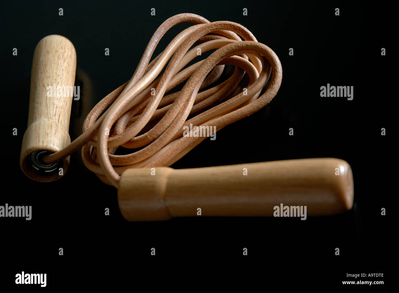 Leather jumping rope over black background Stock Photo - Alamy