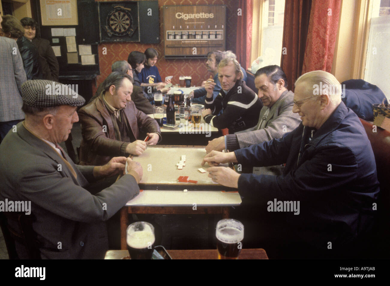 Working class men their local pub, talk drink pints of beer over a game ...