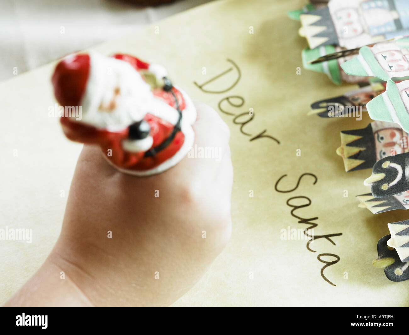 boys hands leaning on table writing dear santa note on paper with ...