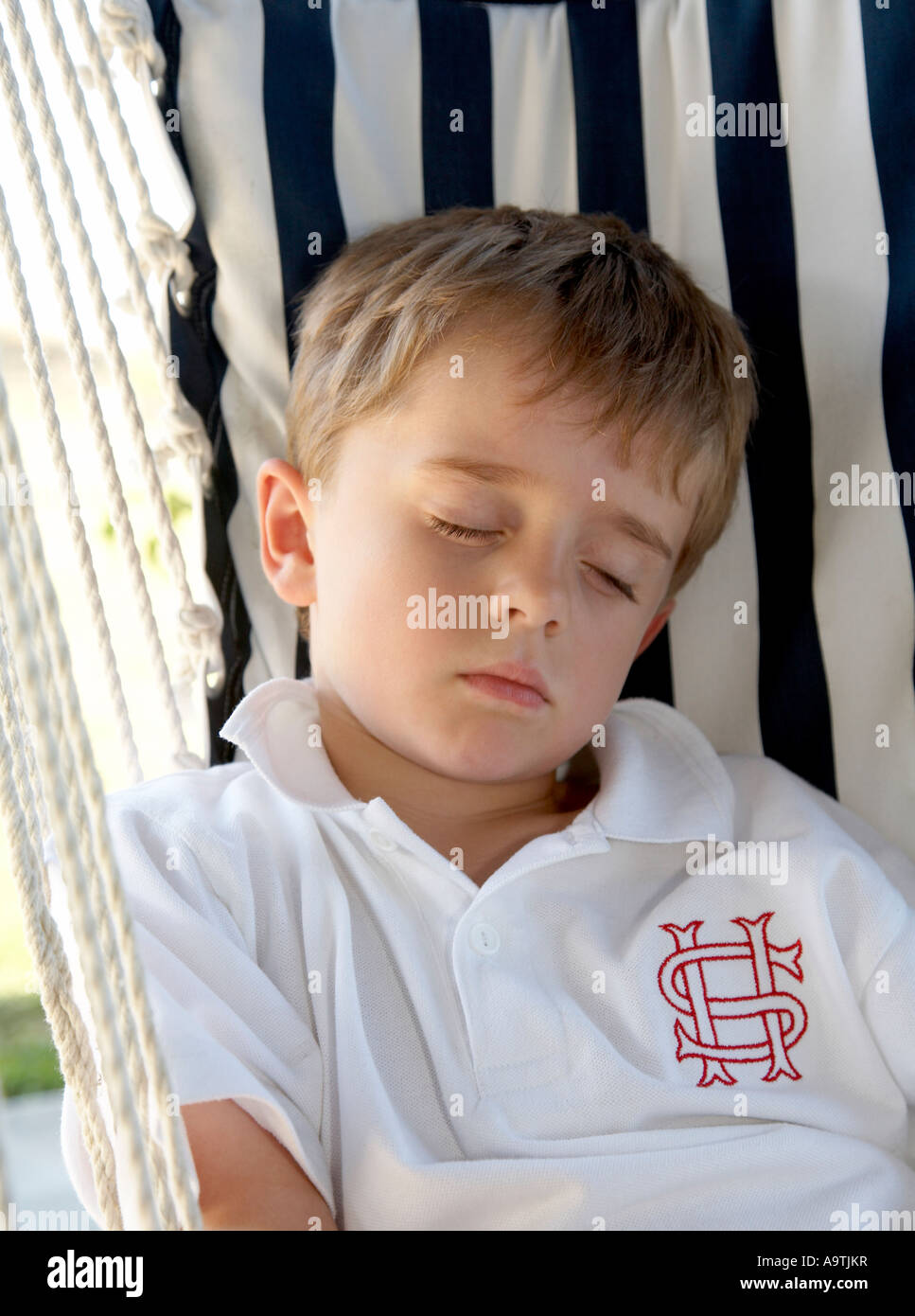 young boy asleep outside in rope chair Stock Photo - Alamy