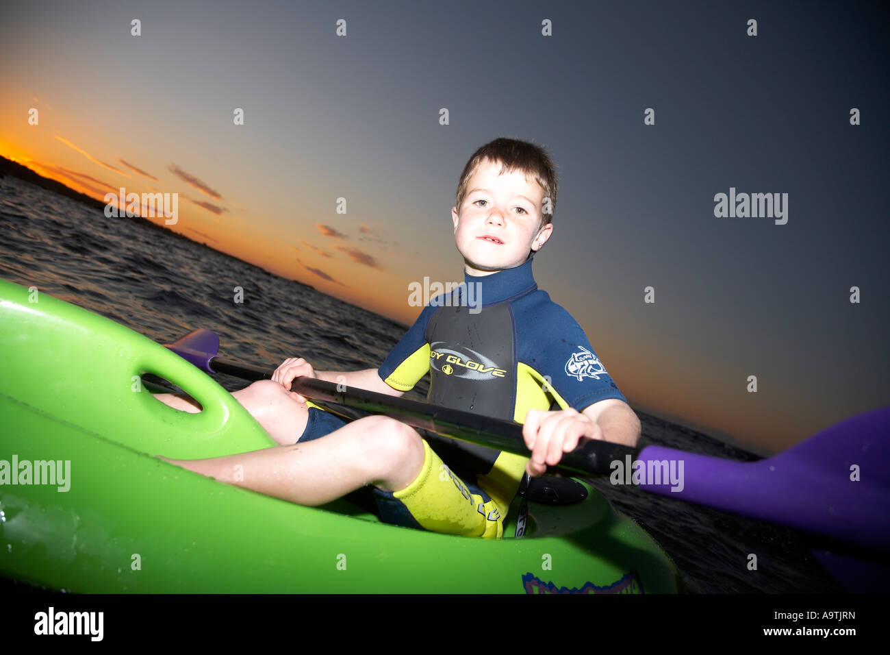 young boy paddleing in kayak at sunset Stock Photo - Alamy