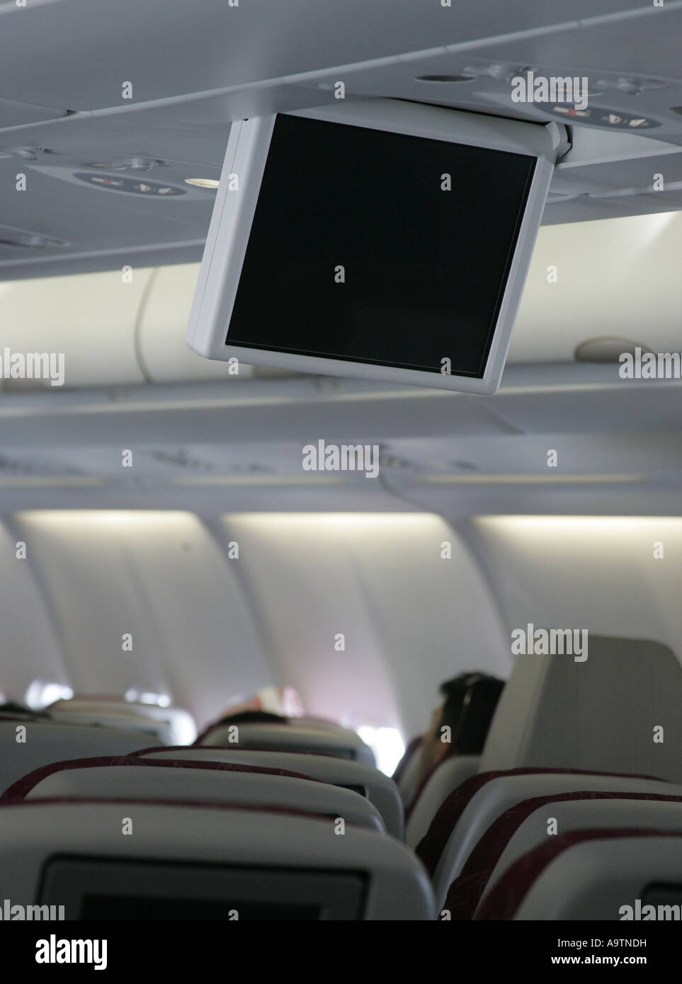Monitor hanging from the cabin ceiling inside a plane Stock Photo - Alamy