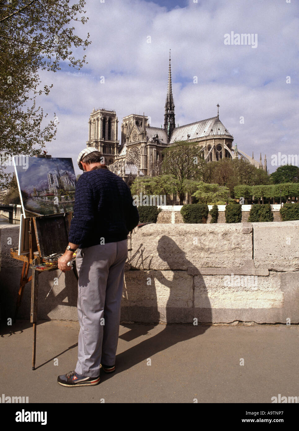 Paris artist & easel painting Notre Dame Cathedral beside the River ...