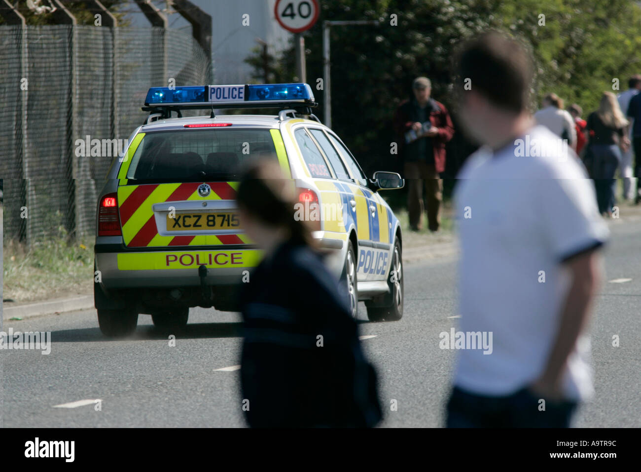 Pedestrians watch PSNI Police Service of Northern Ireland vehicle on ...
