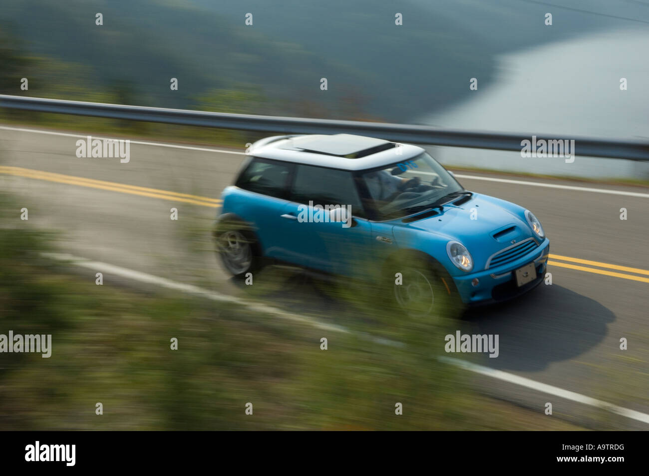 MINI Cooper S being driven on a rural road with a lake in the ...