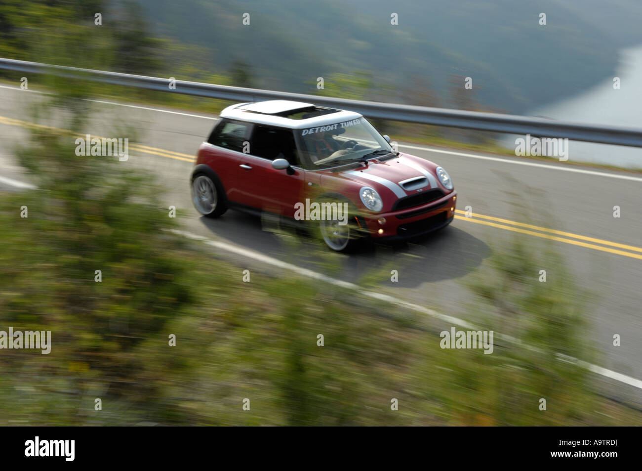 MINI Cooper S being driven on a rural road with a lake in the ...