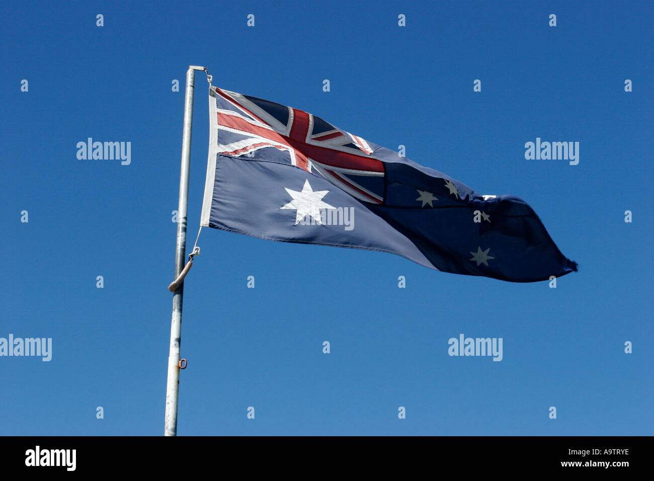 The Australian flag with a bright blue background blowing in the wind ...