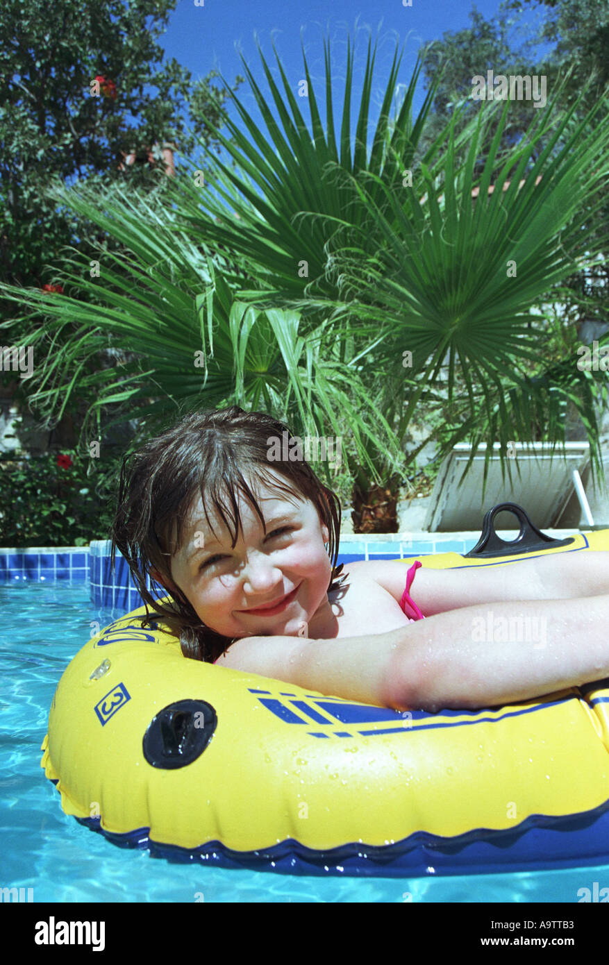 Child enjoying summer holiday in rubber dingy in swimming pool Stock ...
