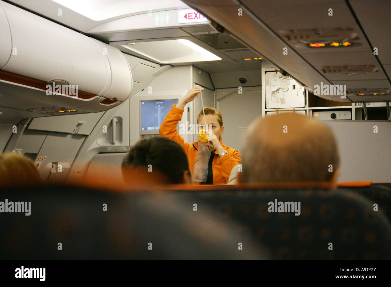 Flight attendant showing emergency procedures to air passengers ...