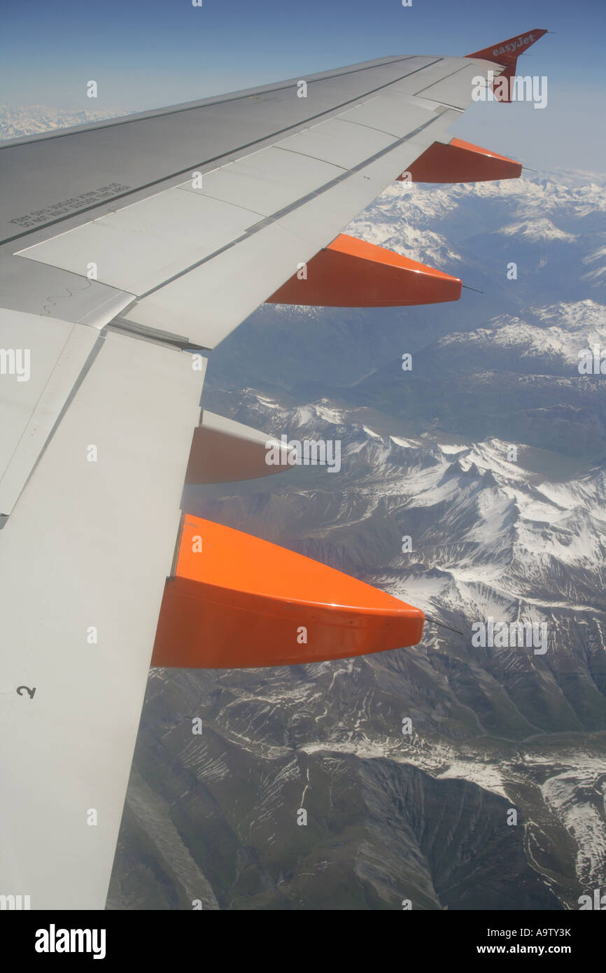 Wing of an easyJet aircraft in flight over the lower Alps mountains ...