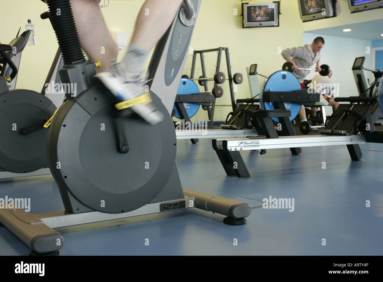 people using gym equipment bicycle Stock Photo - Alamy
