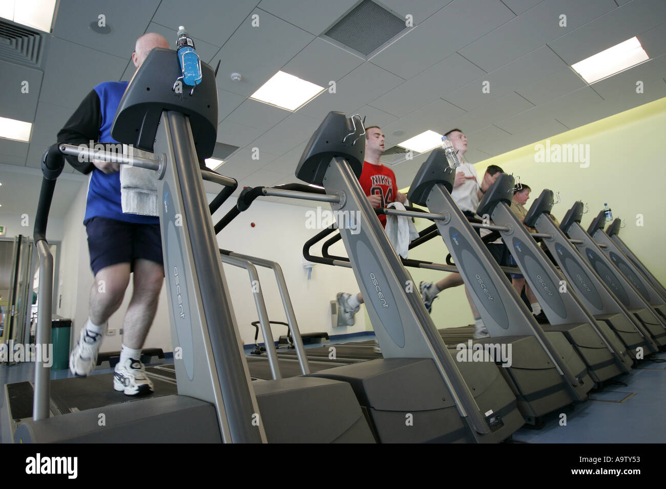 people using gym equipment treadmills walking machines Stock Photo - Alamy