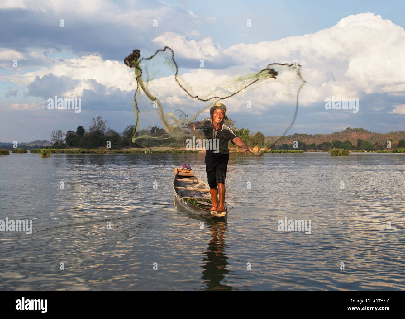 Fisherman Throwing Net Into River Stock Photo - Alamy