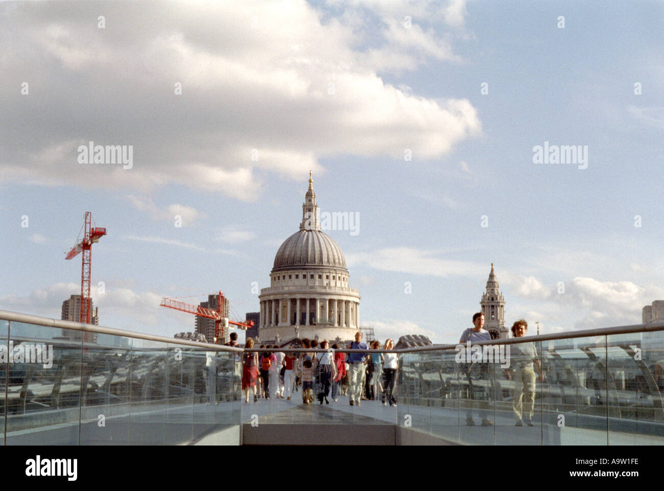 people crossing Millenium Bridge with St Pauls Cathedral London England ...