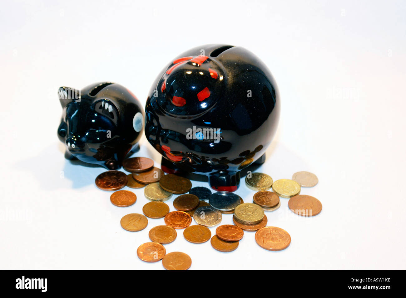 Two black spotted Piggy Bank pigs surrounded by coins Stock Photo - Alamy