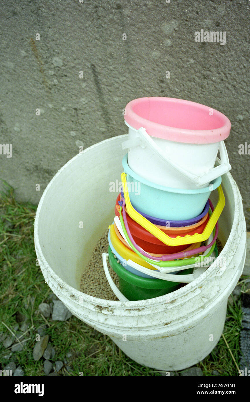 Multi-coloured buckets stacked in a farmyard Stock Photo - Alamy