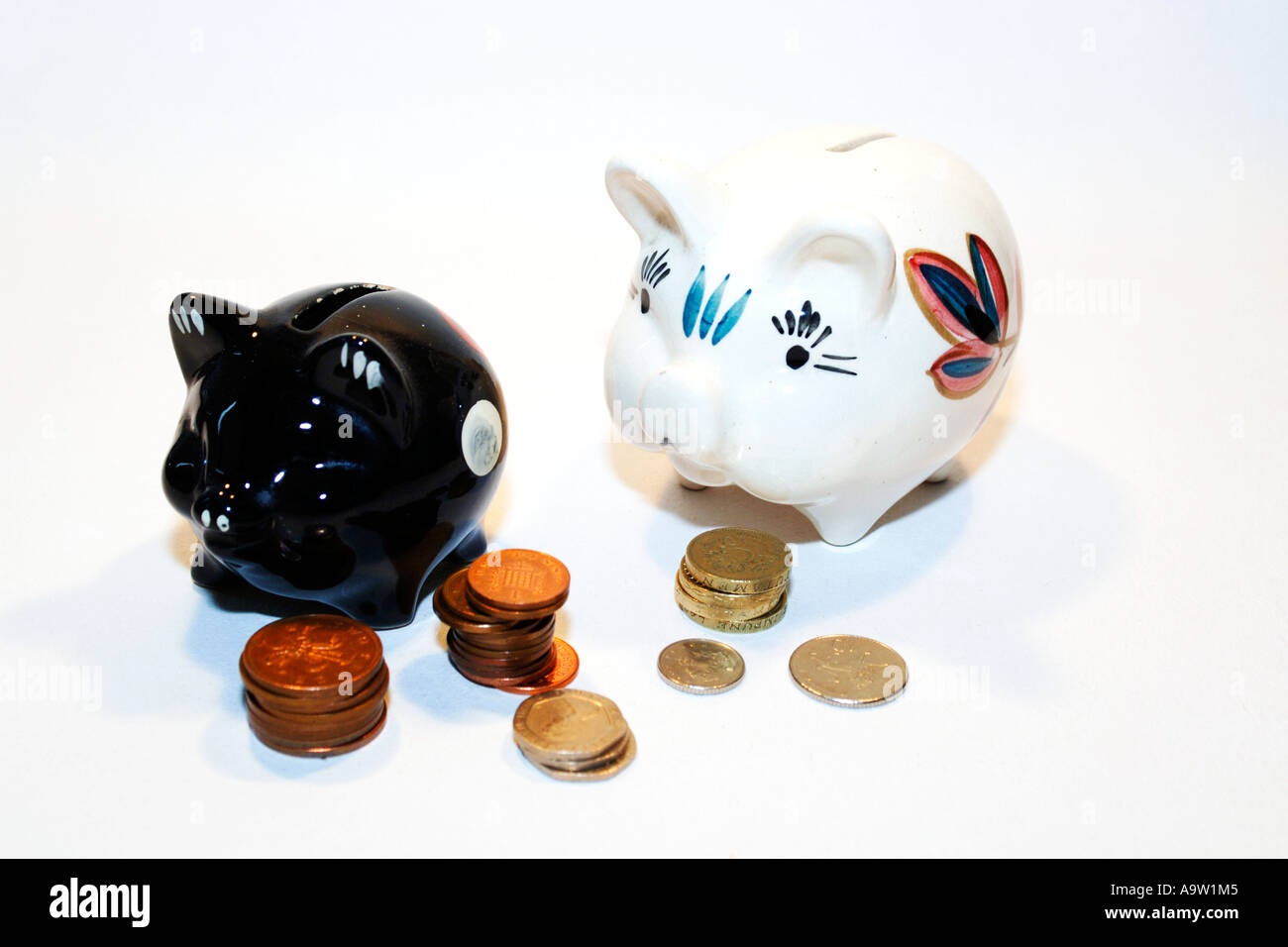 Two spotted Piggy Bank pigs surrounded by coins Stock Photo - Alamy