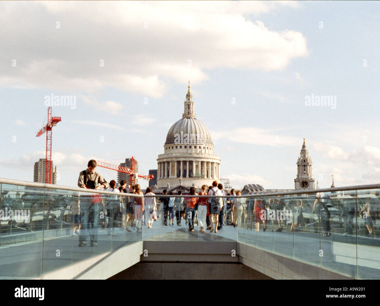 people crossing Millenium Bridge with St Pauls Cathedral London England ...