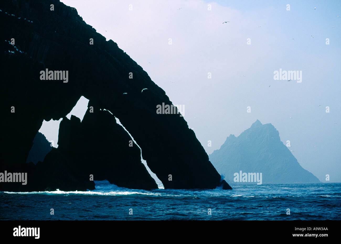 Sea arch on the bird sanctuary island of Little Skellig with monastery ...