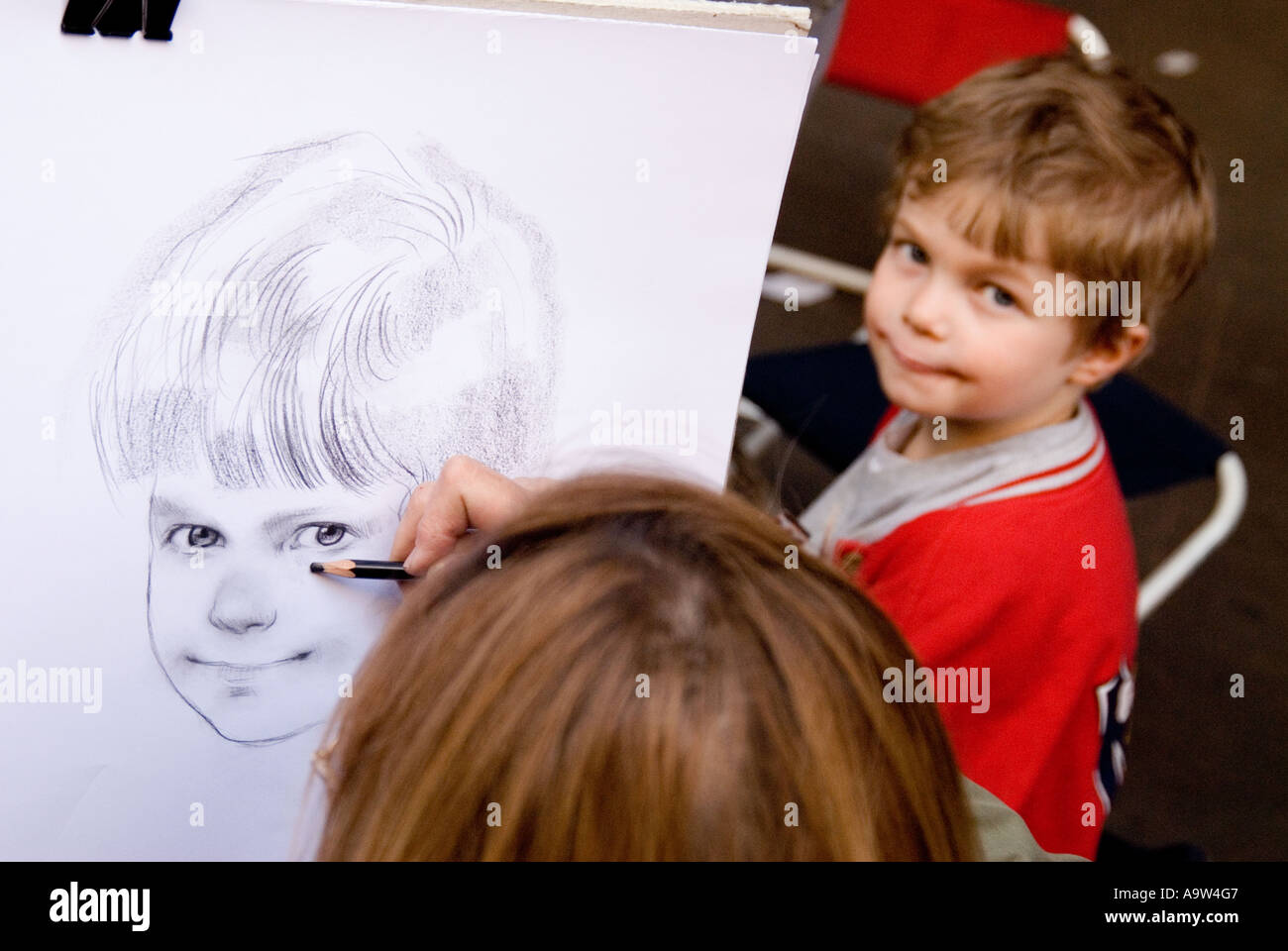 Artist drawing pencil portrait of a child Stock Photo - Alamy
