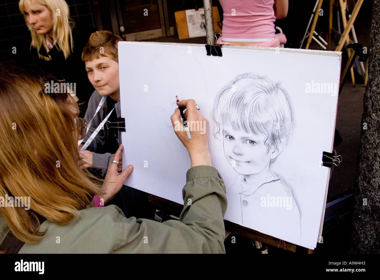Artist drawing pencil portrait of a child Stock Photo - Alamy