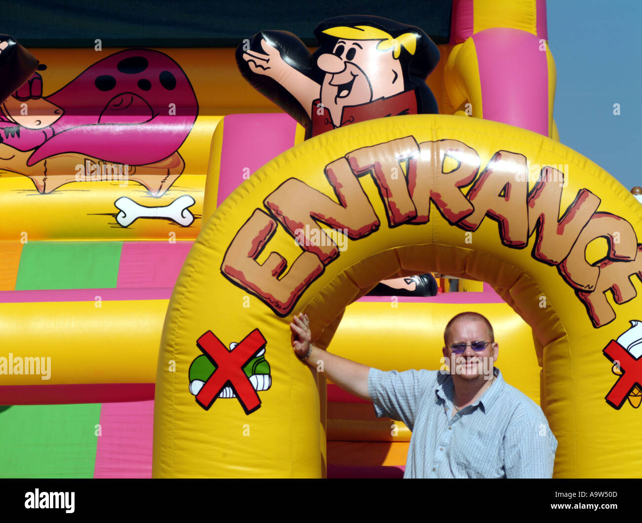 man waiting for customers at funfair inflatable Stock Photo - Alamy