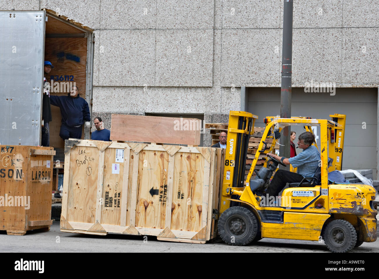 STREET SCENE Chicago Illinois Man use forklift to move wooden crate ...