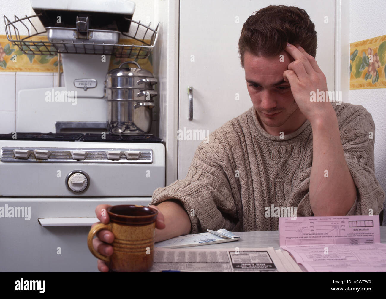 Young man distraught at home in the face of mounting domestic bills ...